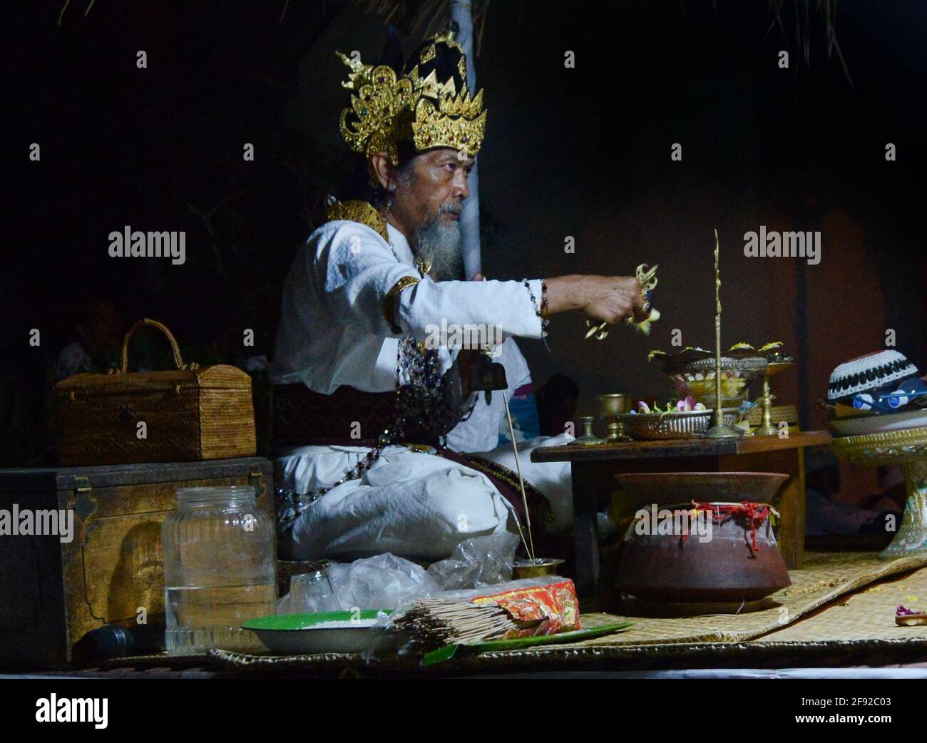 A Balinese Hindu priest conducting a spiritual ceremony during a temple ...