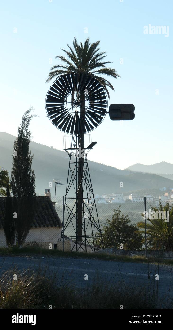 Tall palm tree and old water pump windmill in Andalusian village Stock ...
