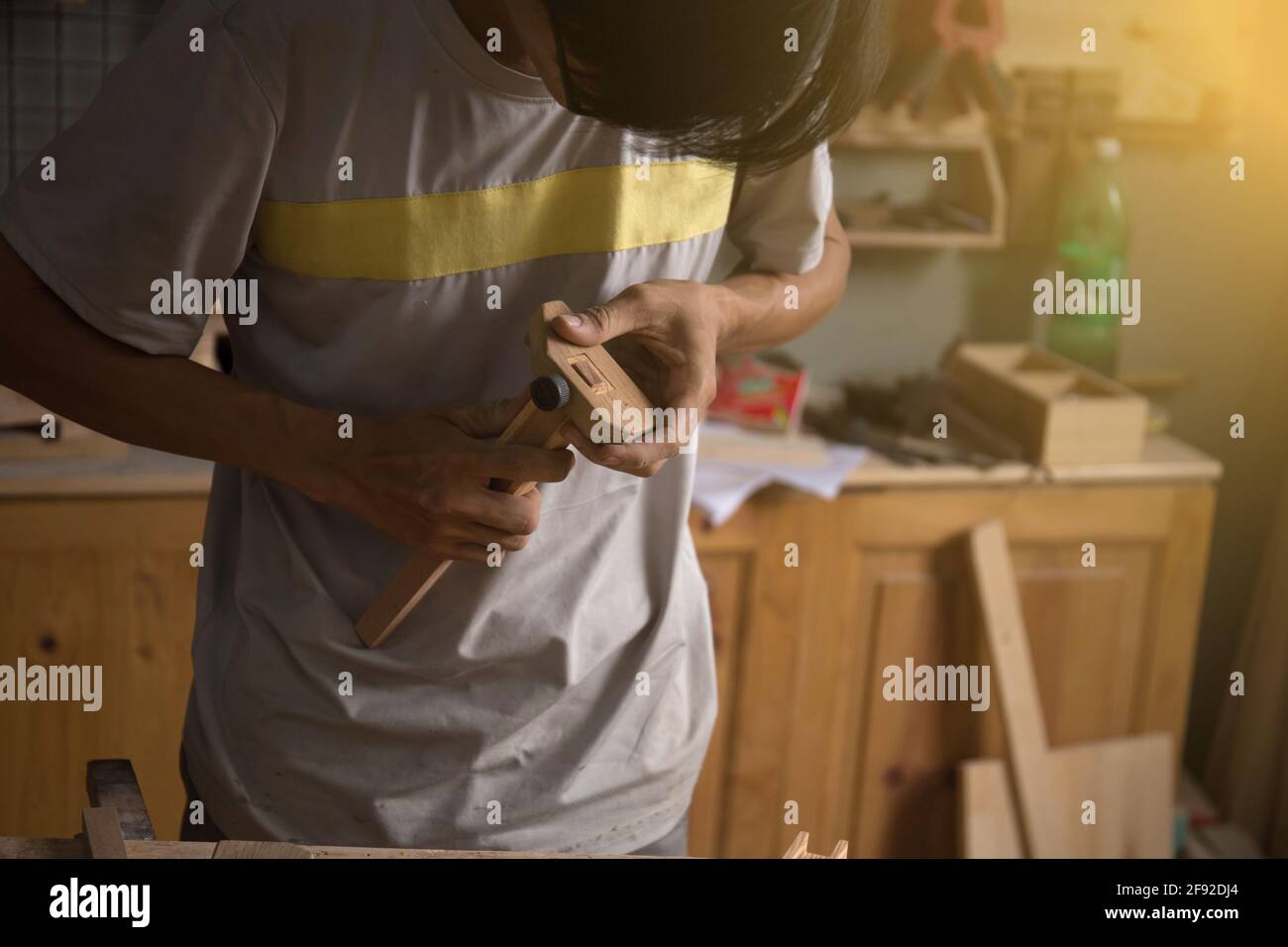 Closeup of a young Vietnamese male fixing wooden details Stock Photo ...