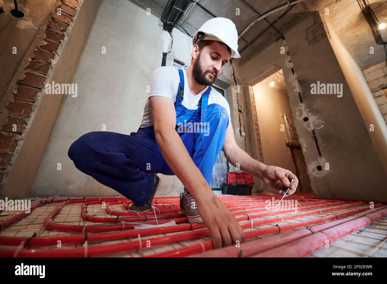 Horizontal, low angle view portrait of young plumber wearing blue ...