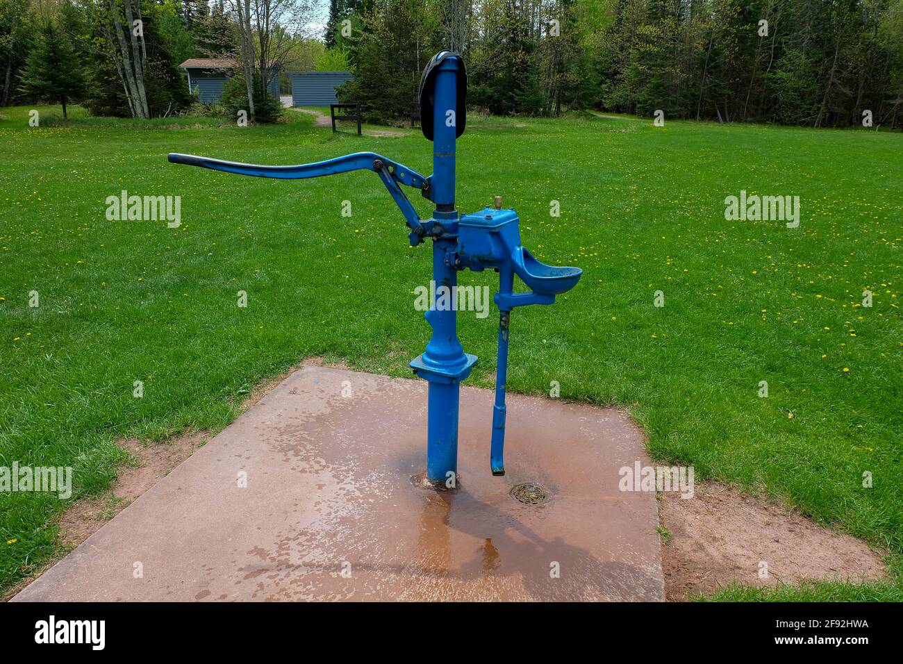 Blue hand pump for water from a well in the green field Stock Photo - Alamy