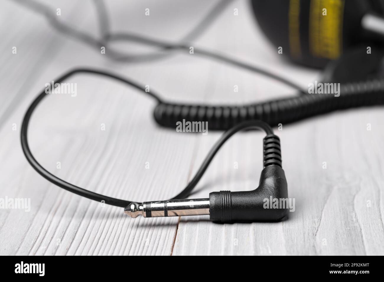 Black headphones with wire on wooden background Stock Photo - Alamy