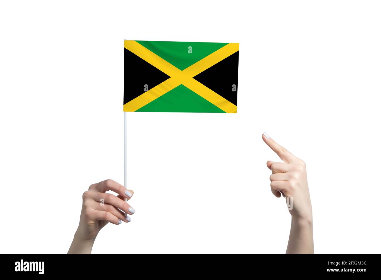 A beautiful female hand holds a Jamaica flag to which she shows the ...