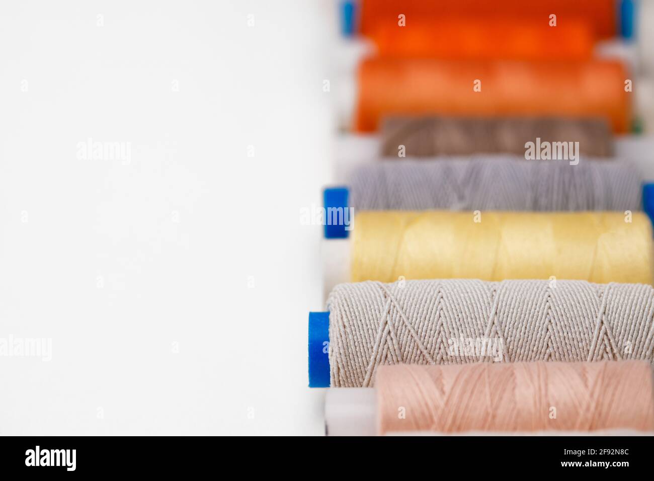 Colored spools of threads on white background Stock Photo - Alamy