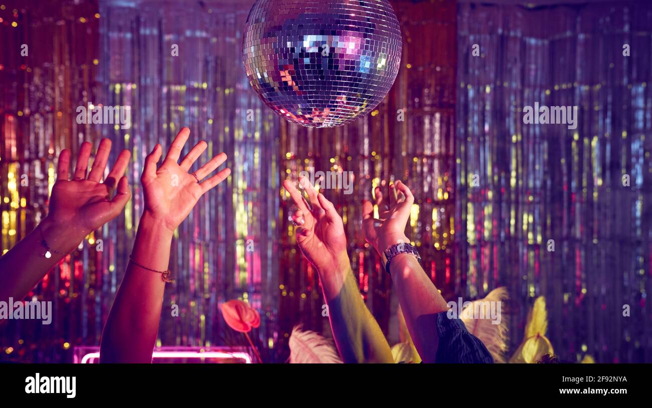 Disco dancing underneath the disco ball with hands in the air Stock ...