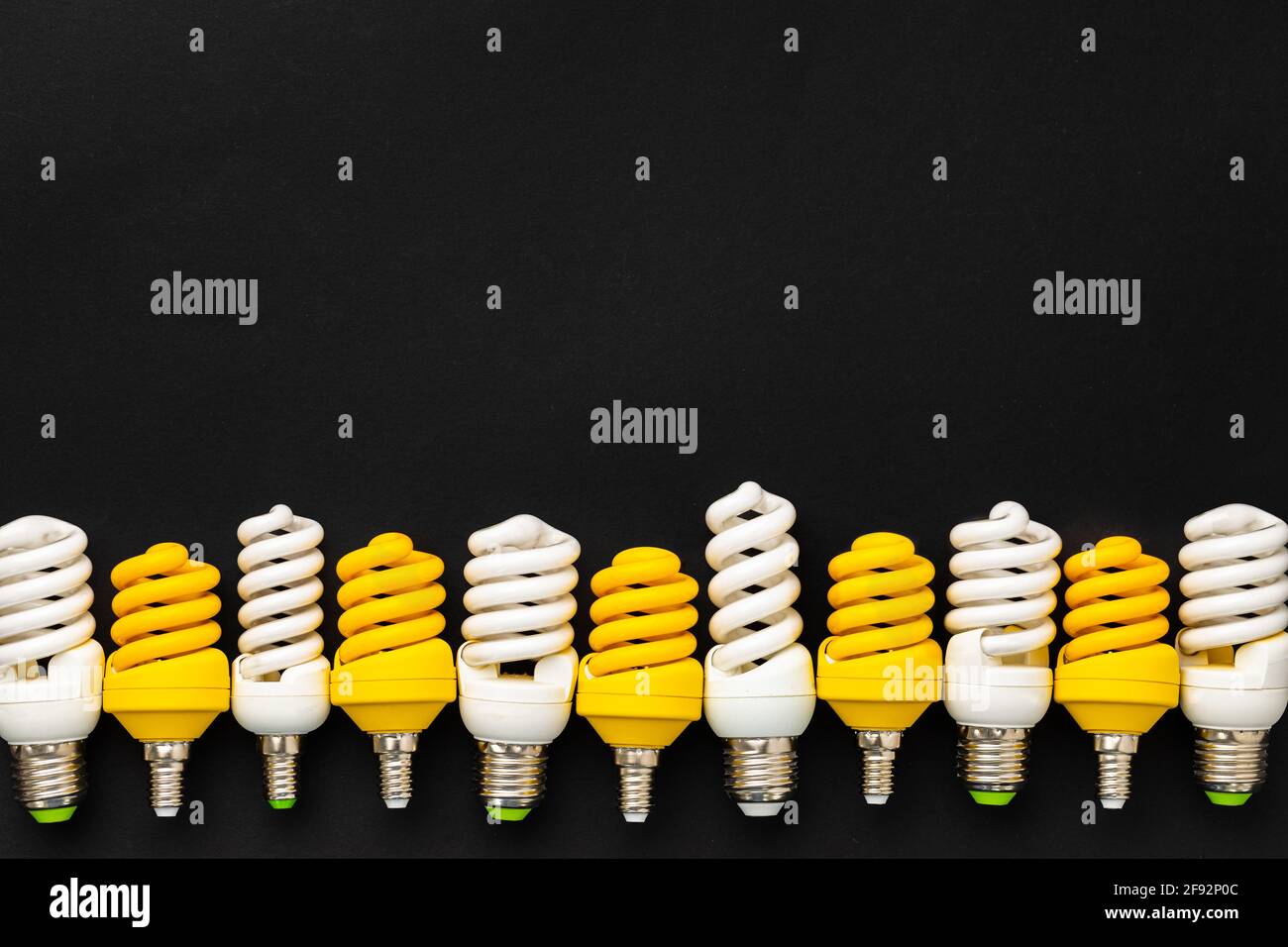 White and yellow light bulbs on black background Stock Photo - Alamy