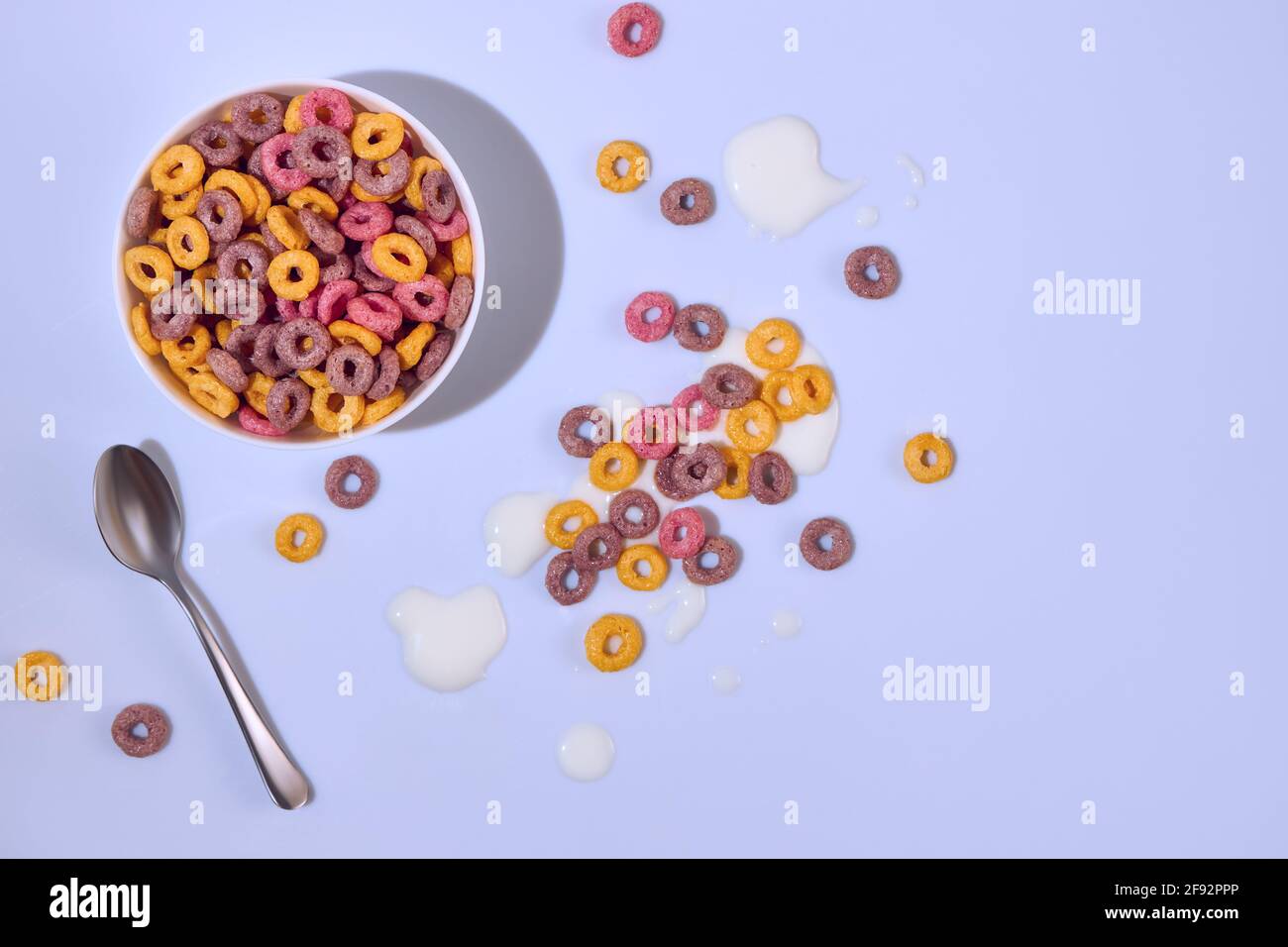 Colorful corn rings in a bowl on a colored background. Cornflakes are ...