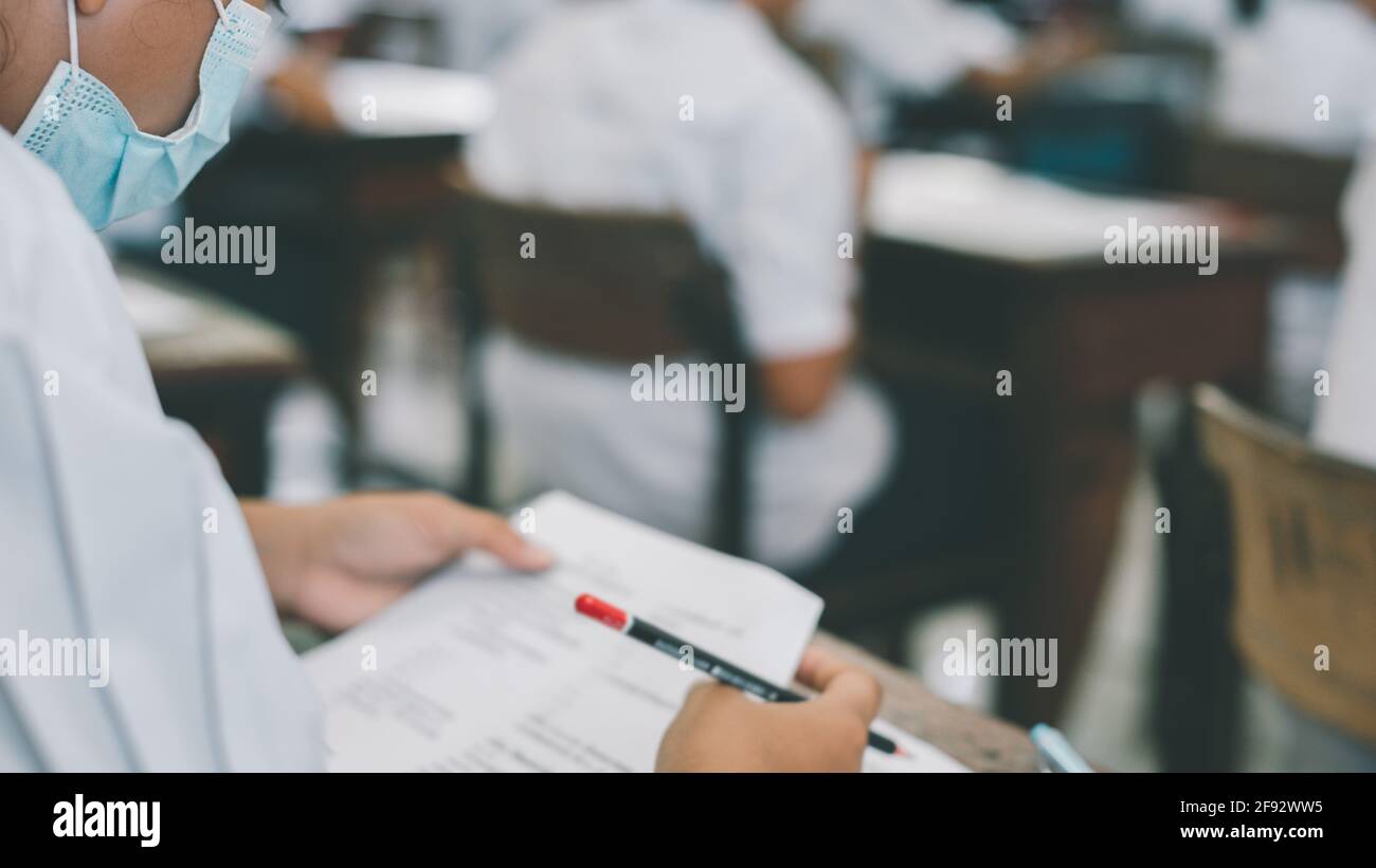 Students wearing mask for protect covid-19 and doing exam in classroom ...