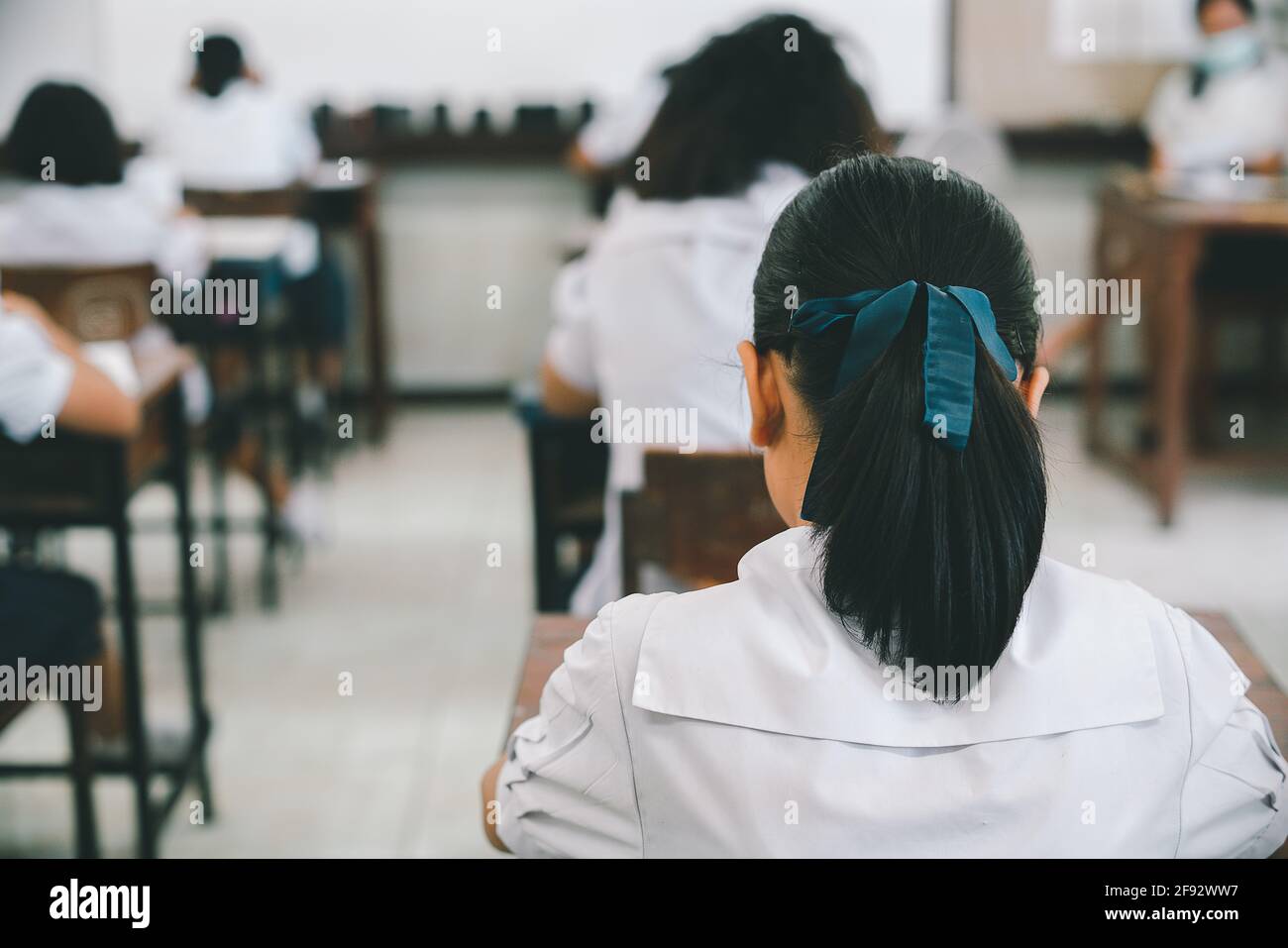 Students doing exam in classroom with stress Stock Photo - Alamy