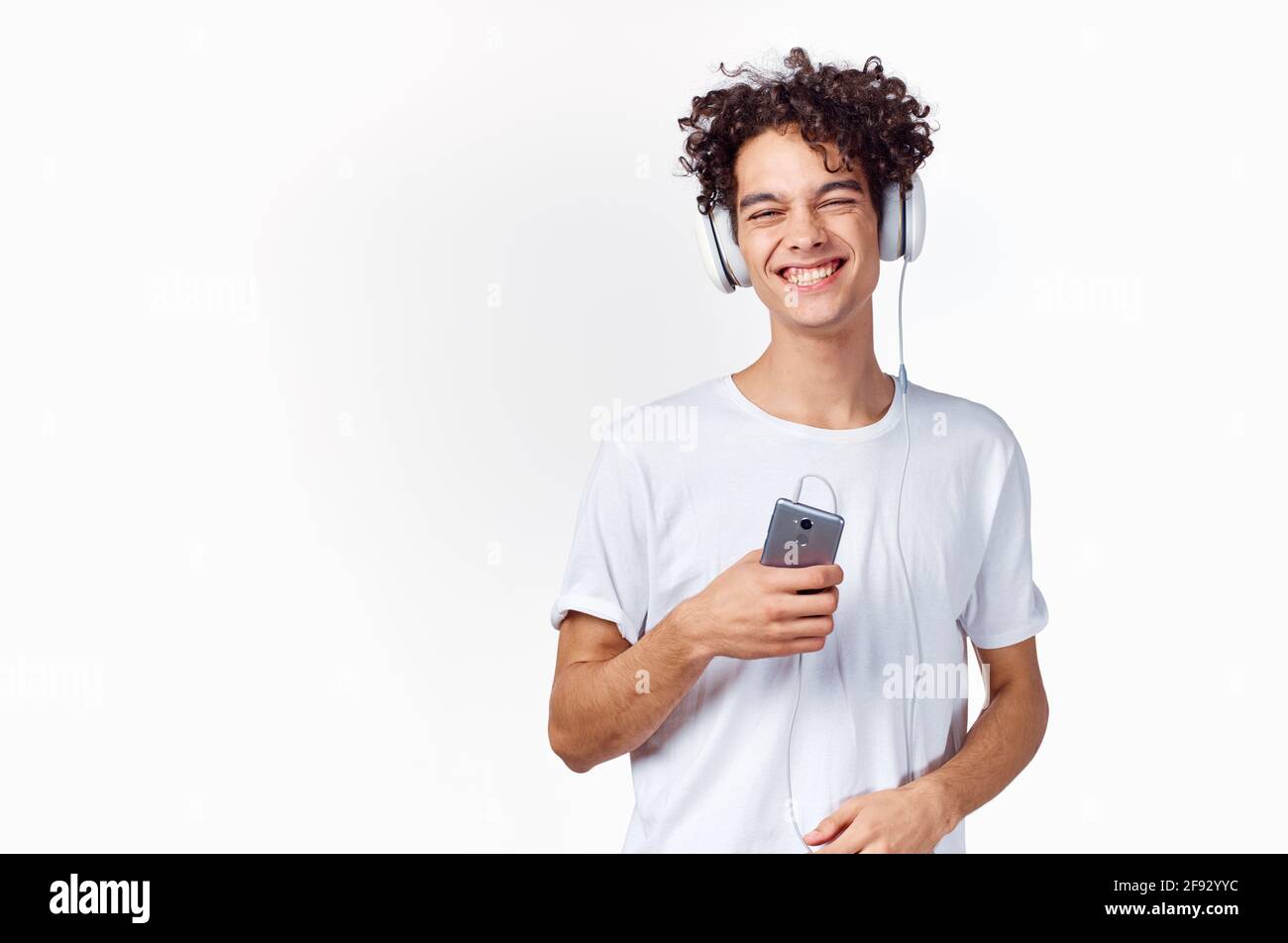 joyful guy in headphones listens to music emotions light background ...