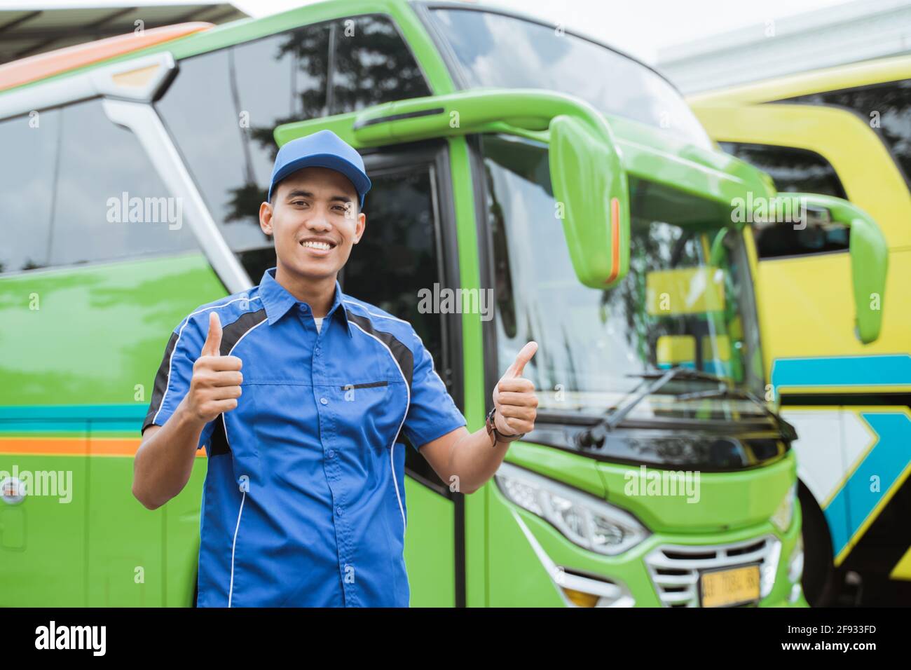 A handsome bus driver in uniform and hat smiles with thumbs up Stock ...