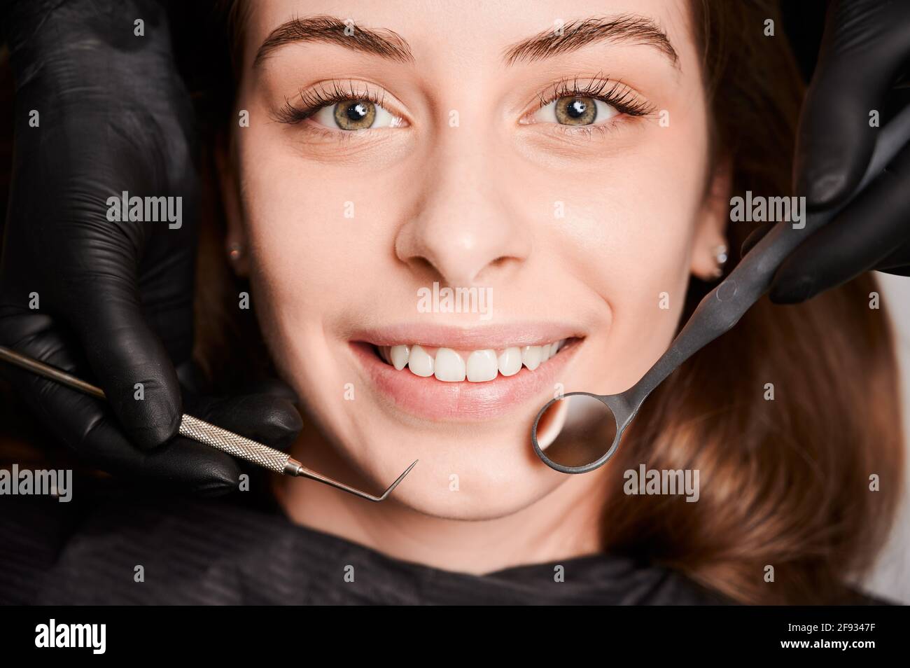 Close up portrait of beautiful young smiling woman lying in dental ...