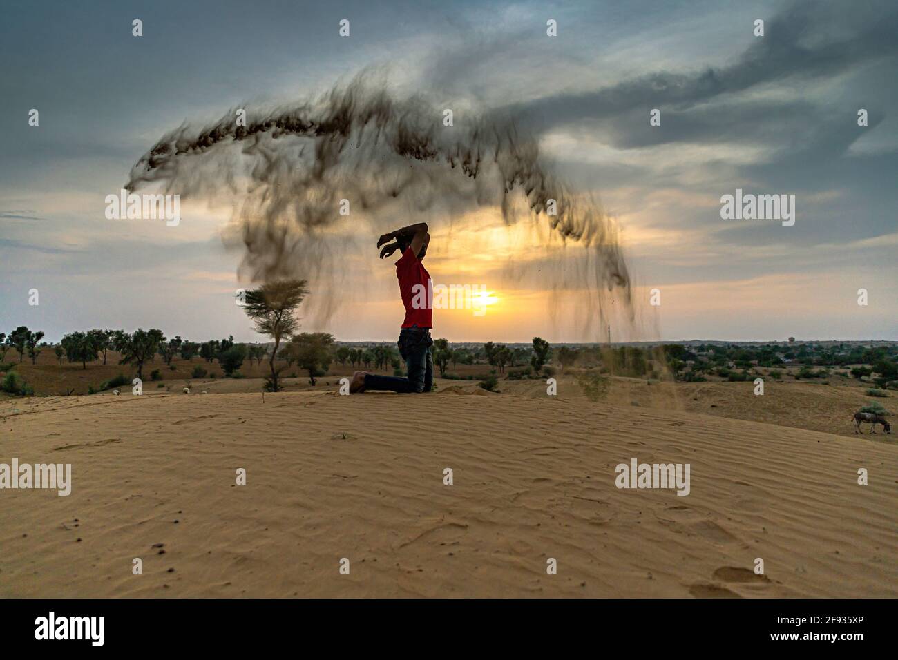 unidentified man throwing with sand in the air at thar desert jaisalmer ...