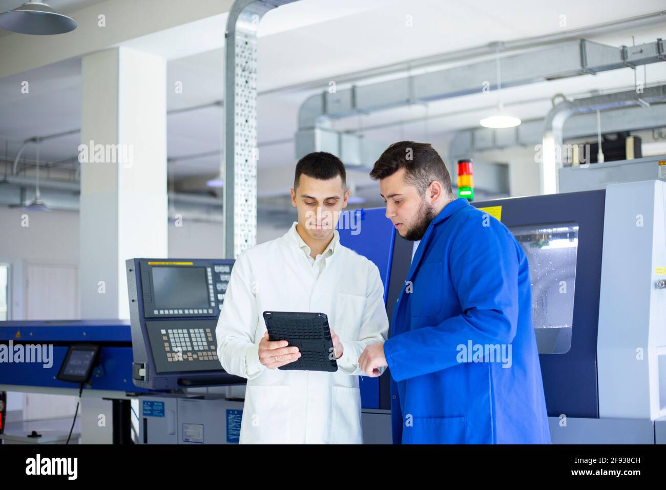 Engineer and technician discussing production process at factory Stock ...