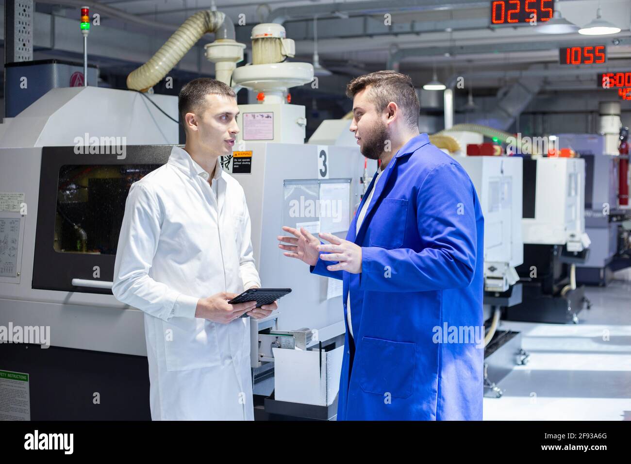 Engineer and technician discussing production process at factory Stock ...