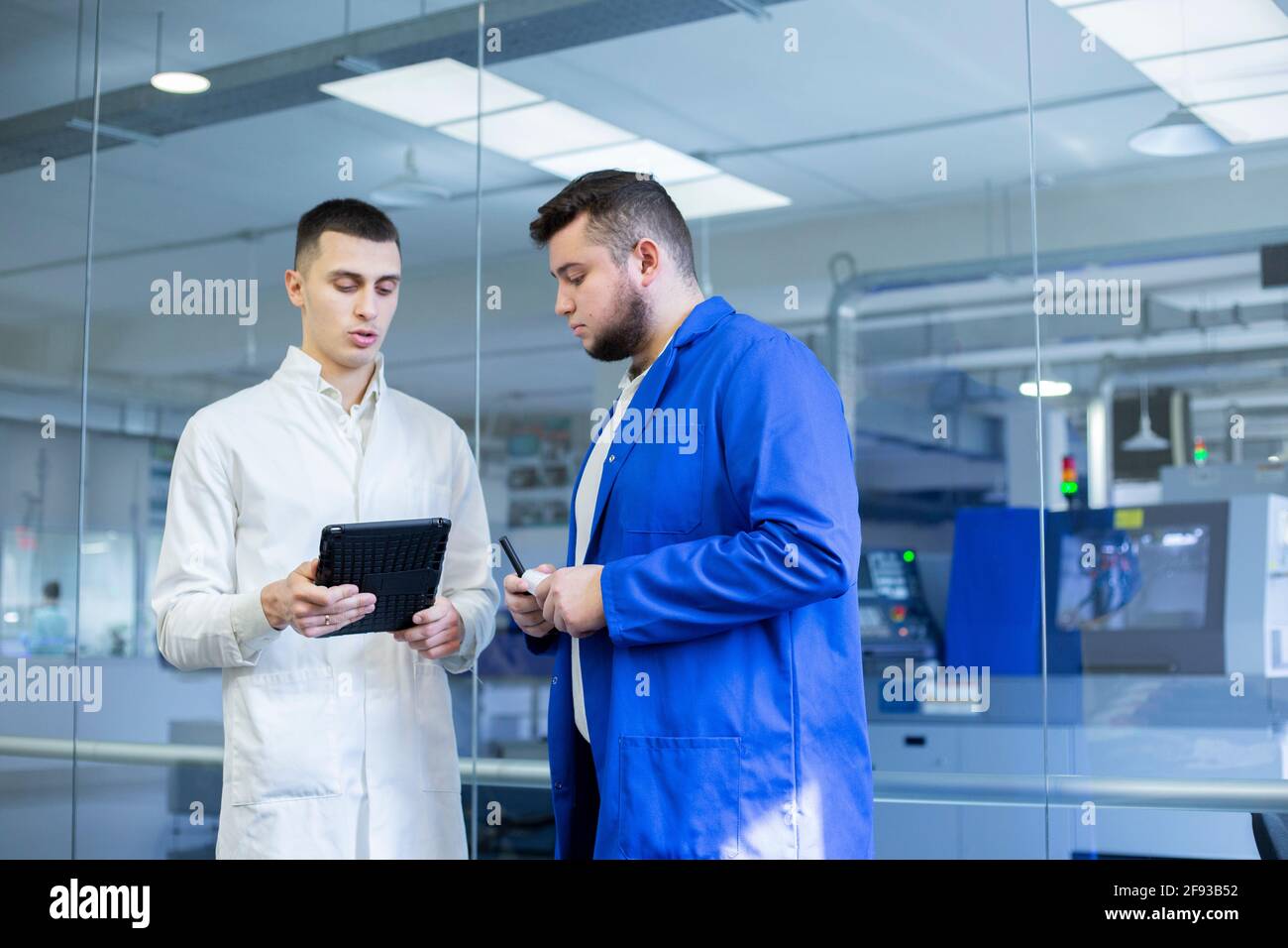 Engineer and technician discussing production process at factory Stock ...