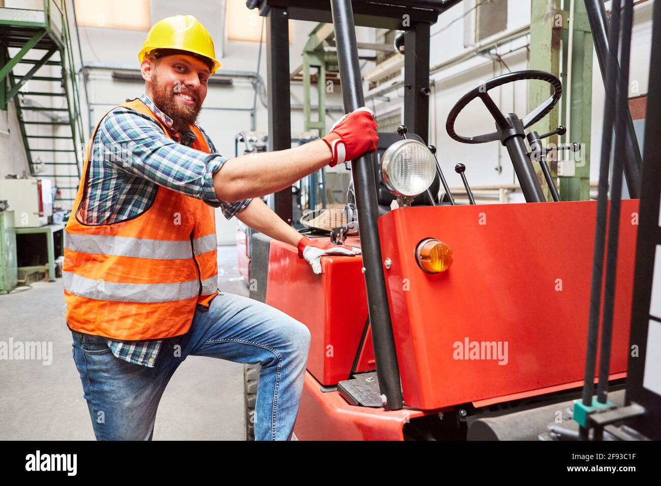 Young worker as a warehouse clerk with forklift driver training in the ...