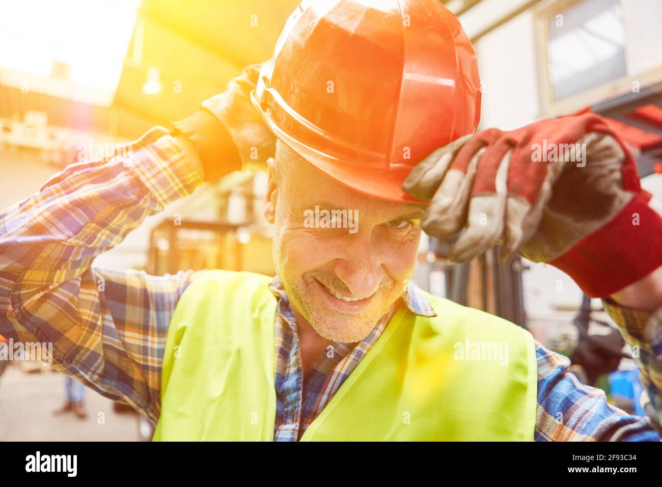 Worker with hard hat when helmets are mandatory as occupational safety ...