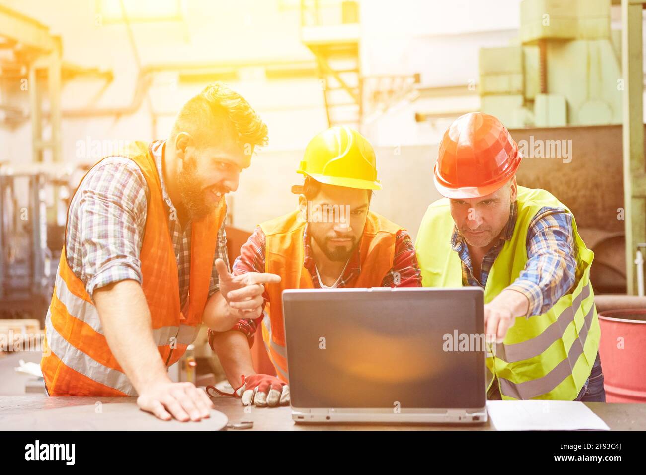 Metal construction workers team at laptop computer for planning and ...