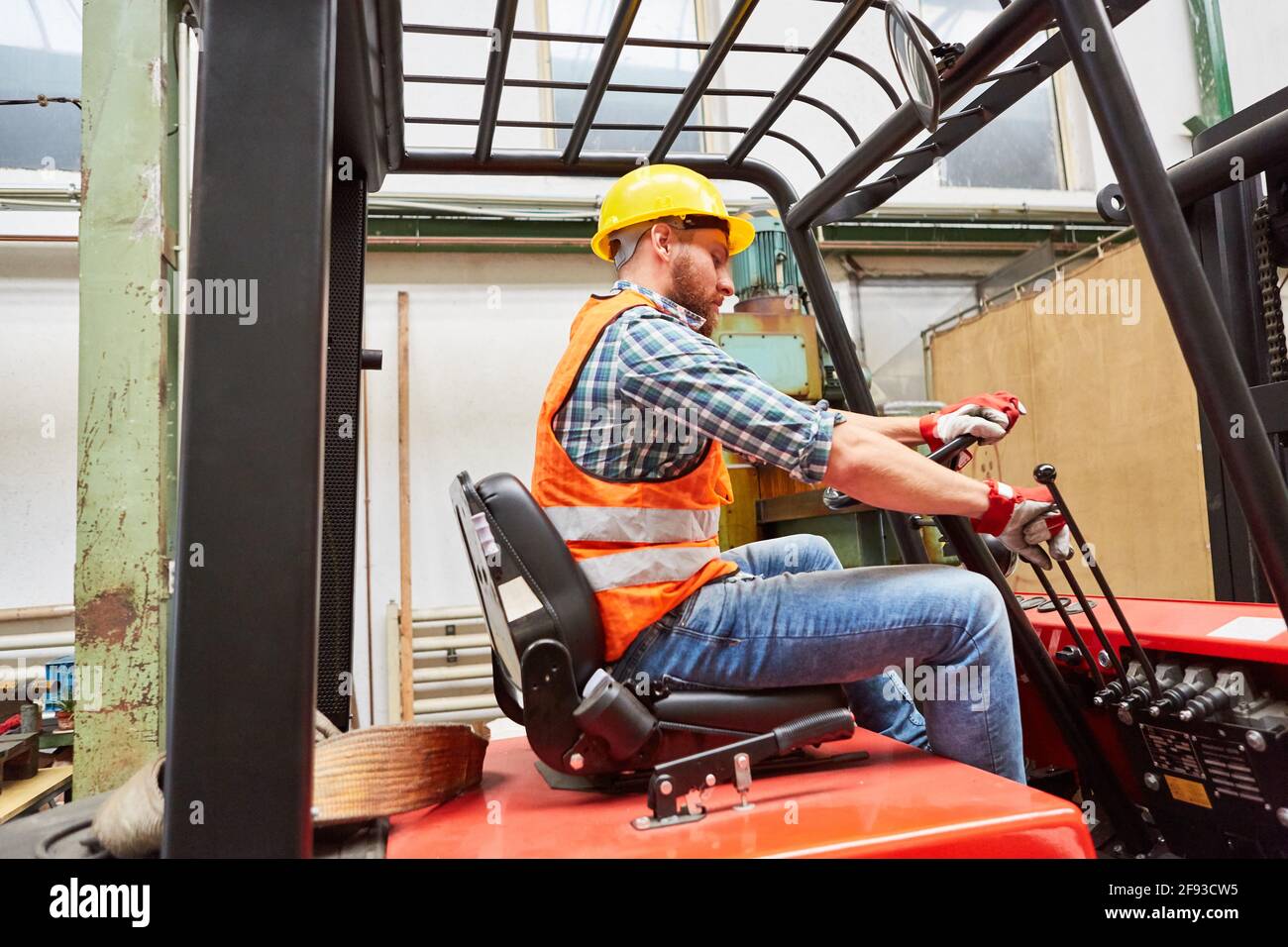 Warehouse worker as a forklift driver while driving a forklift in the ...