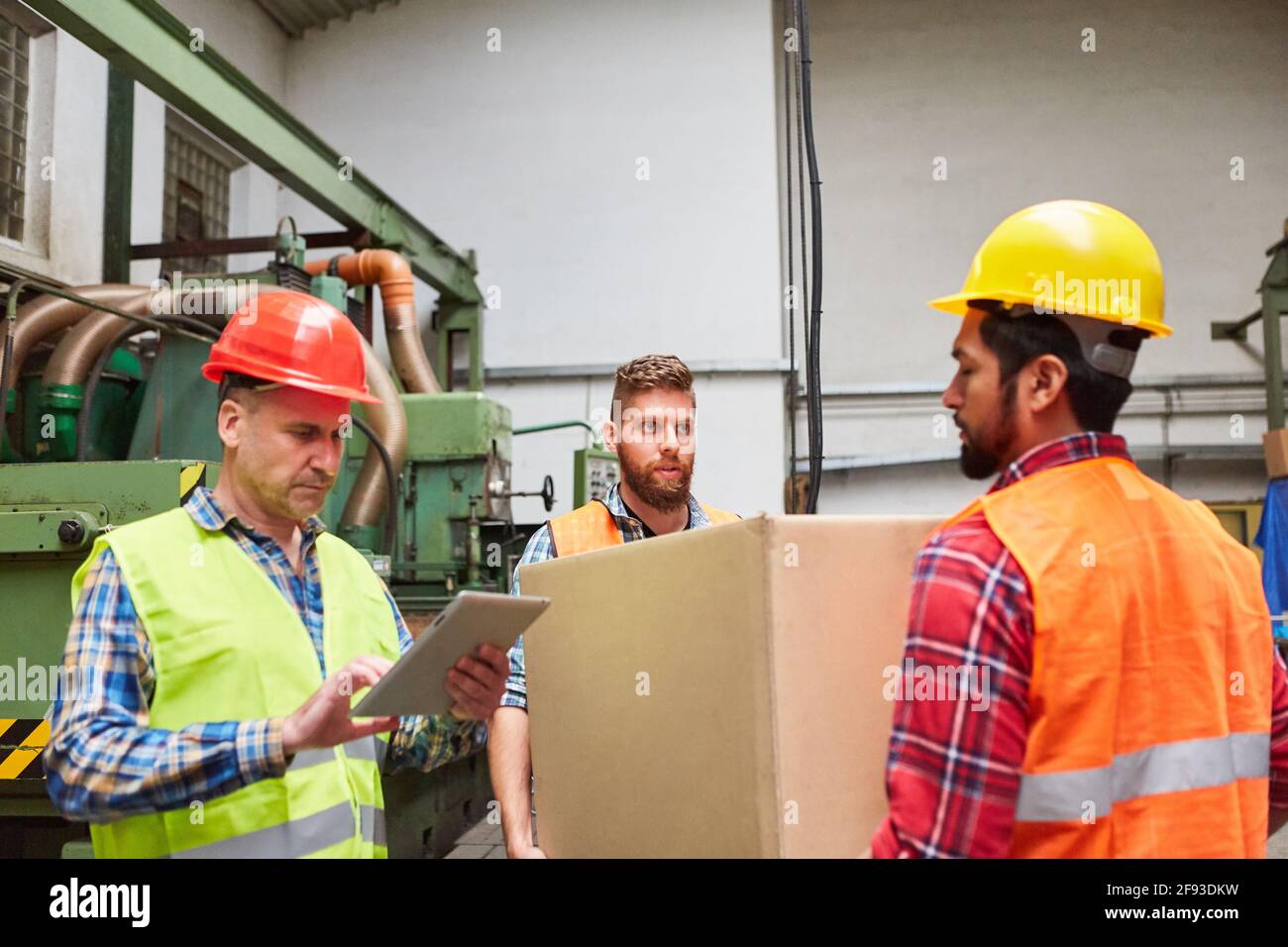 Order picker and warehouse worker with a package during an inspection ...