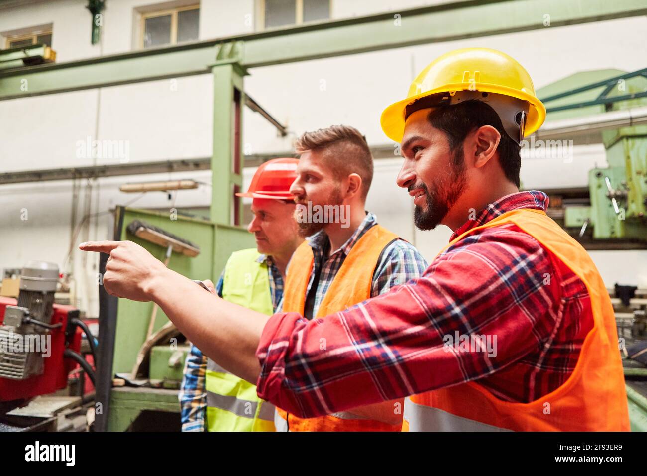 Craftsmen and metal workers discuss an order in the workshop of the ...