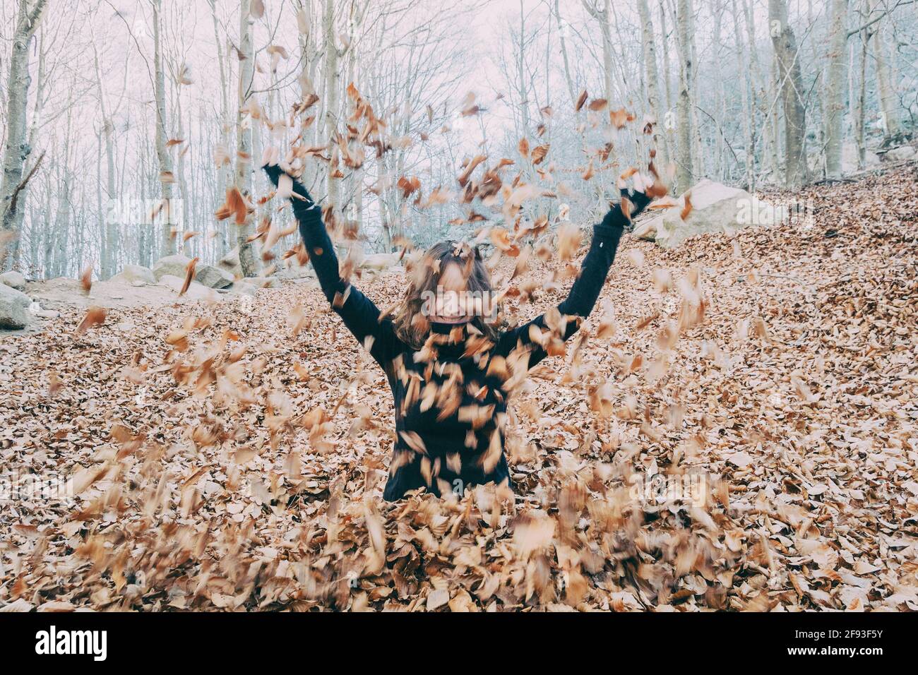 woman enjoying autumn and catching falling yellow leaves Stock Photo ...