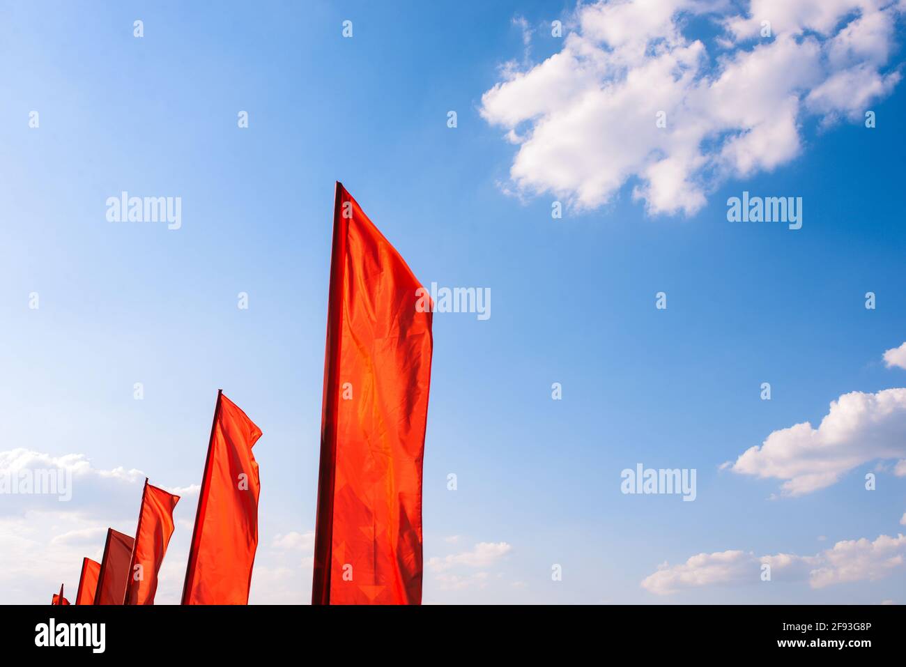 Red flags and blue sky with clouds. The symbol of victory and struggle ...