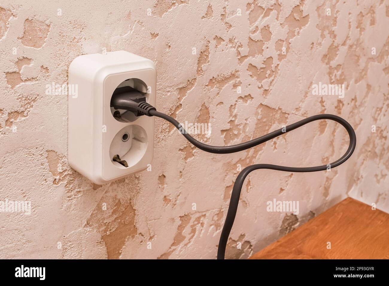 Plug in a double outlet on a white plaster background in a modern room ...