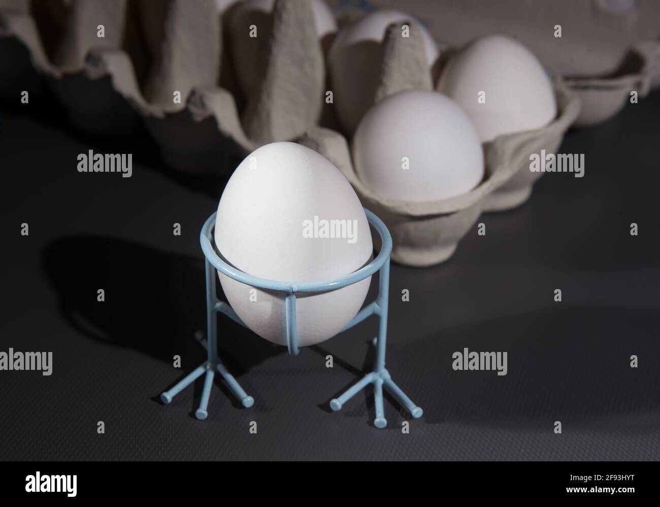 Chicken egg in a special stand in the form of chicken legs. Cardboard ...