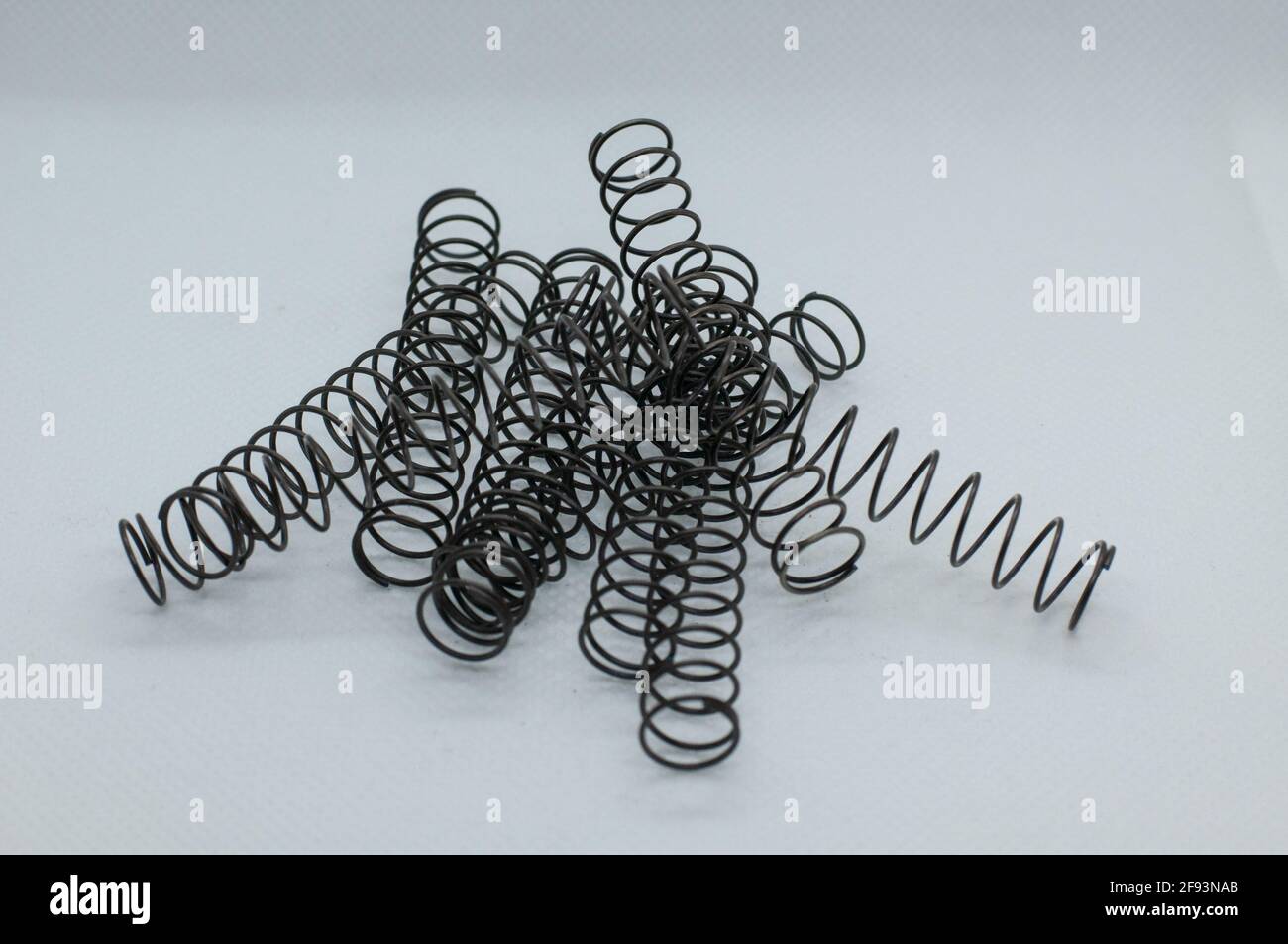 Shot of many springs on each other in a plain background Stock Photo ...