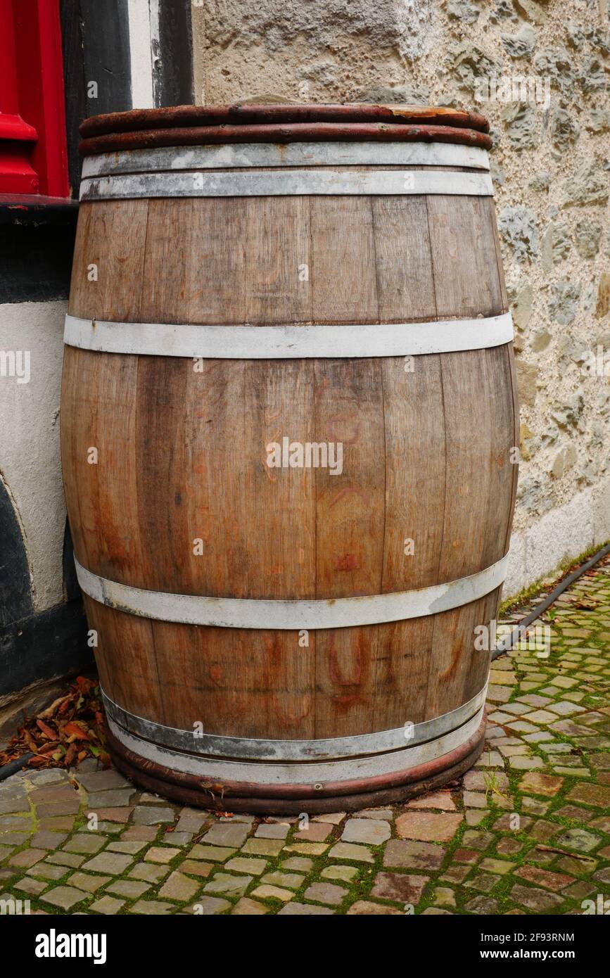 old wooden barrel in front of a stone wall and red window Stock Photo ...