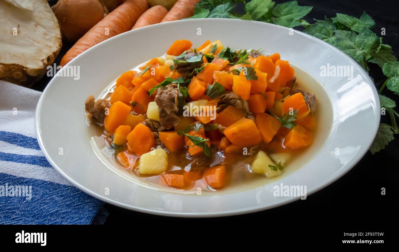 Closeup of a delicious carrot stew with beef served on a white plate ...