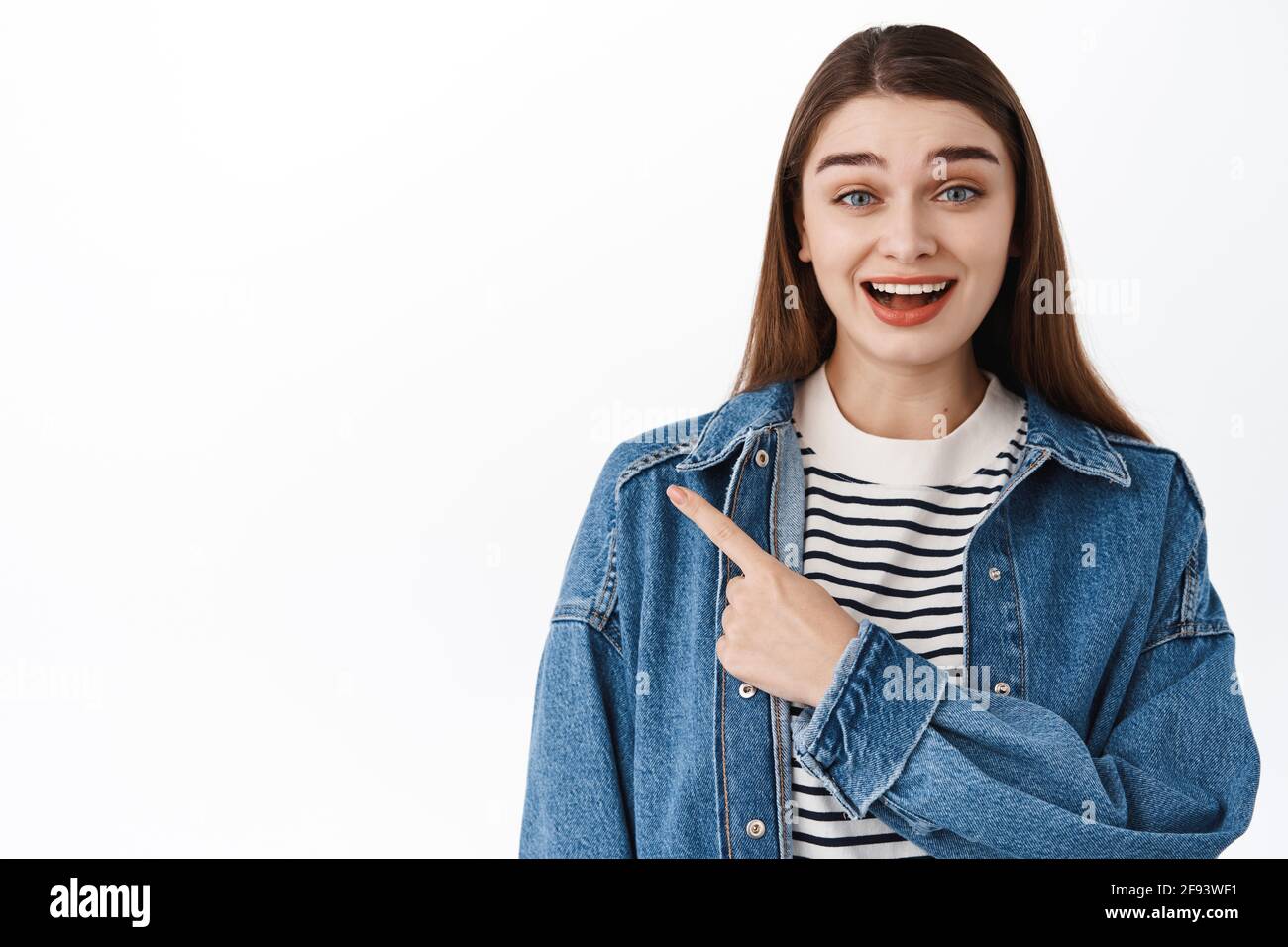 Excited smiling girl student pointing aside at left side with ...