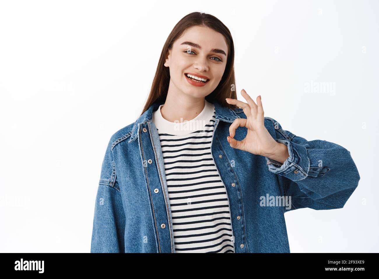 Okay you alright. Smiling happy girl shows OK sign in approval, give ...