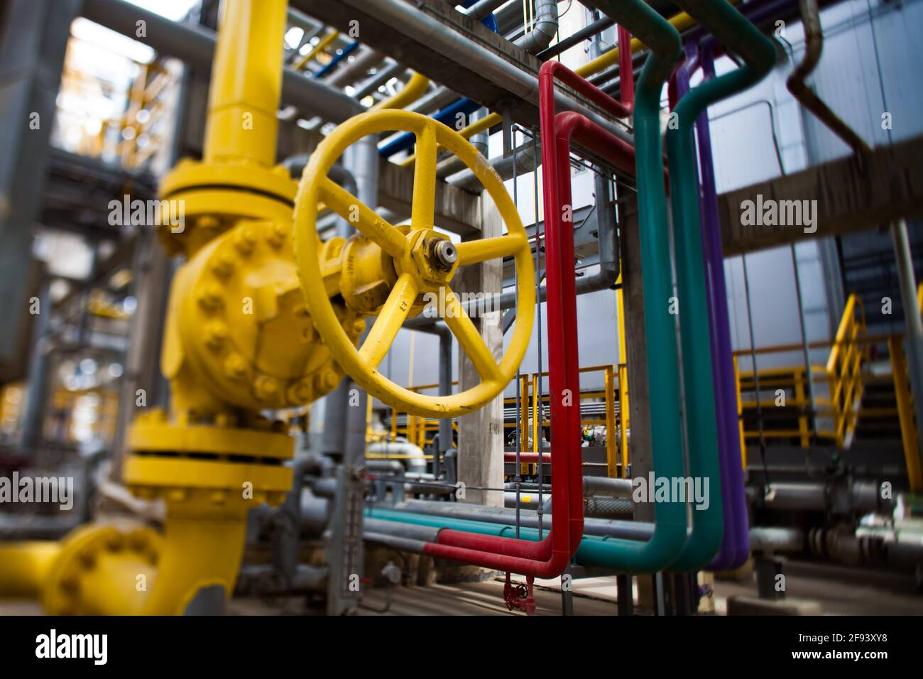 Oil refinery plant. Close-up of yellow gas valve and high-pressure ...