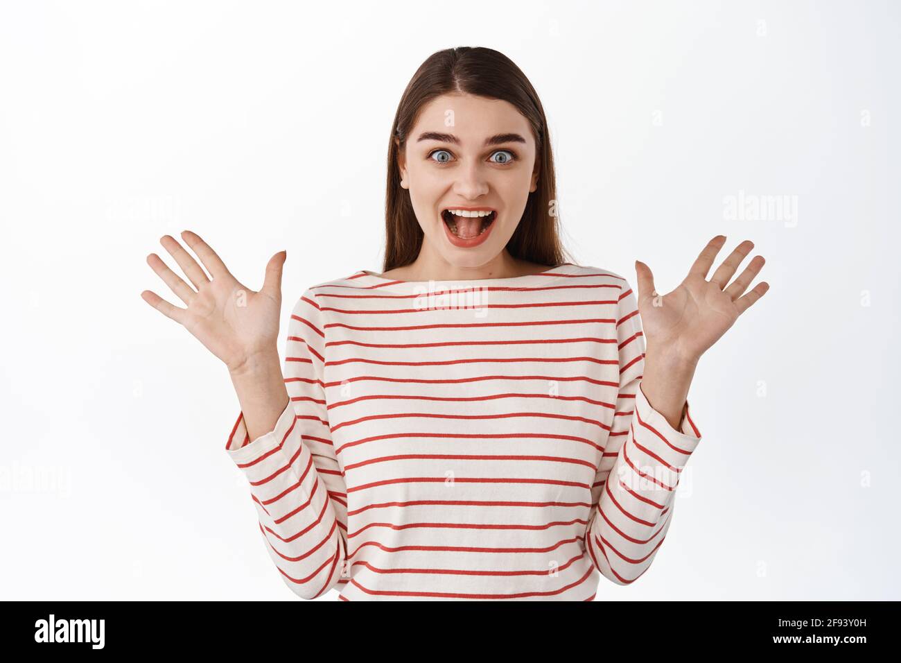 Portrait of young woman shouting from surprise and happiness, smiling ...