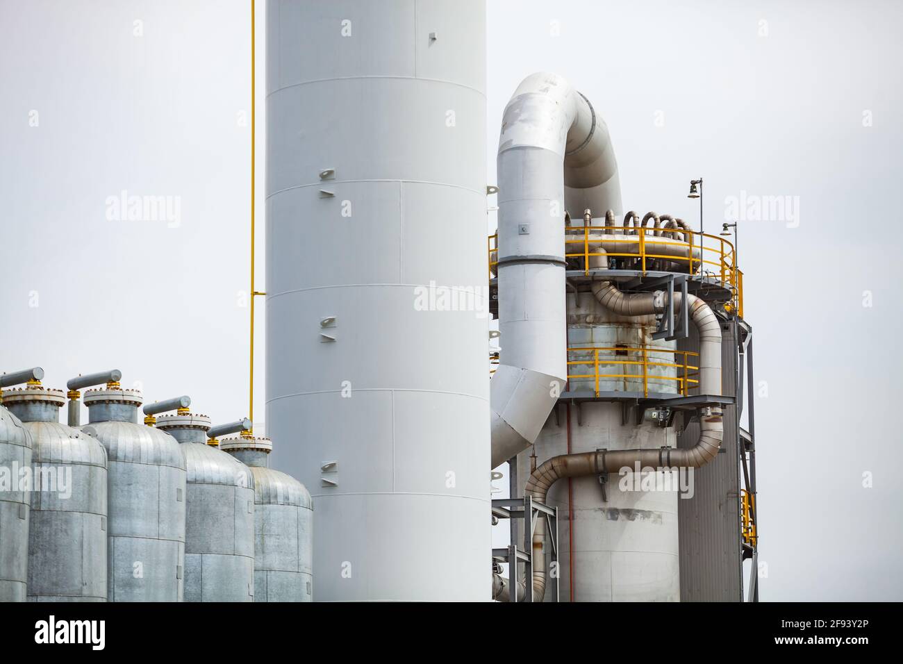 White and galvanized tanks on grey sky background. Oil refinery plant ...