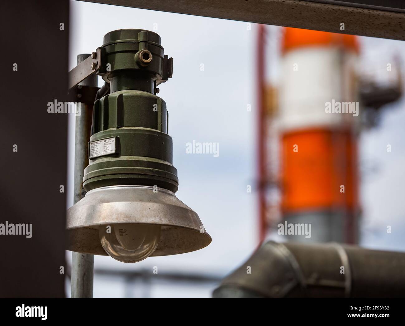Orange and white stripped distillation tower (right, out of focus) and ...