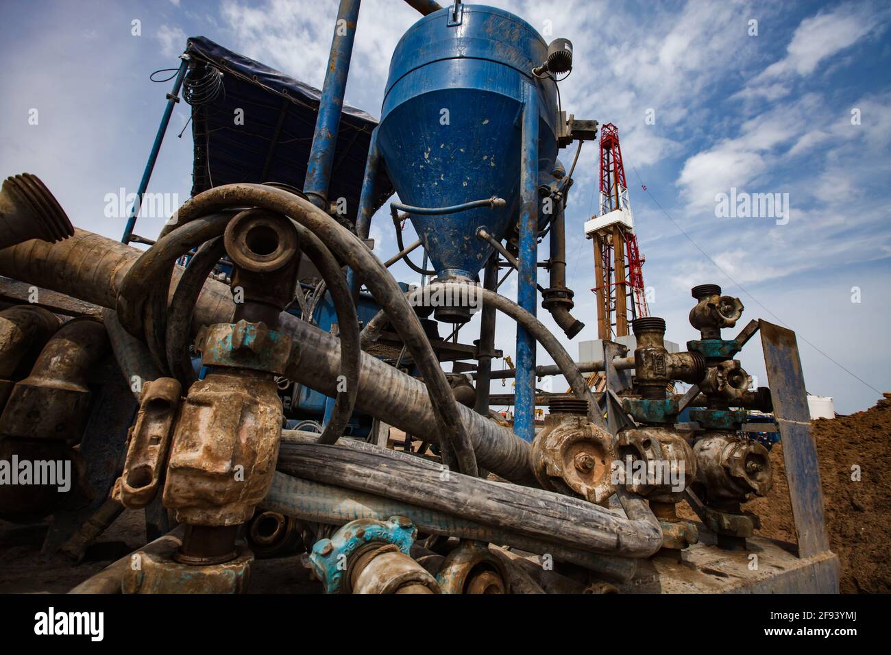 Rusted mud pumping machine left. Oil drill rig (derrick) right.Oil ...