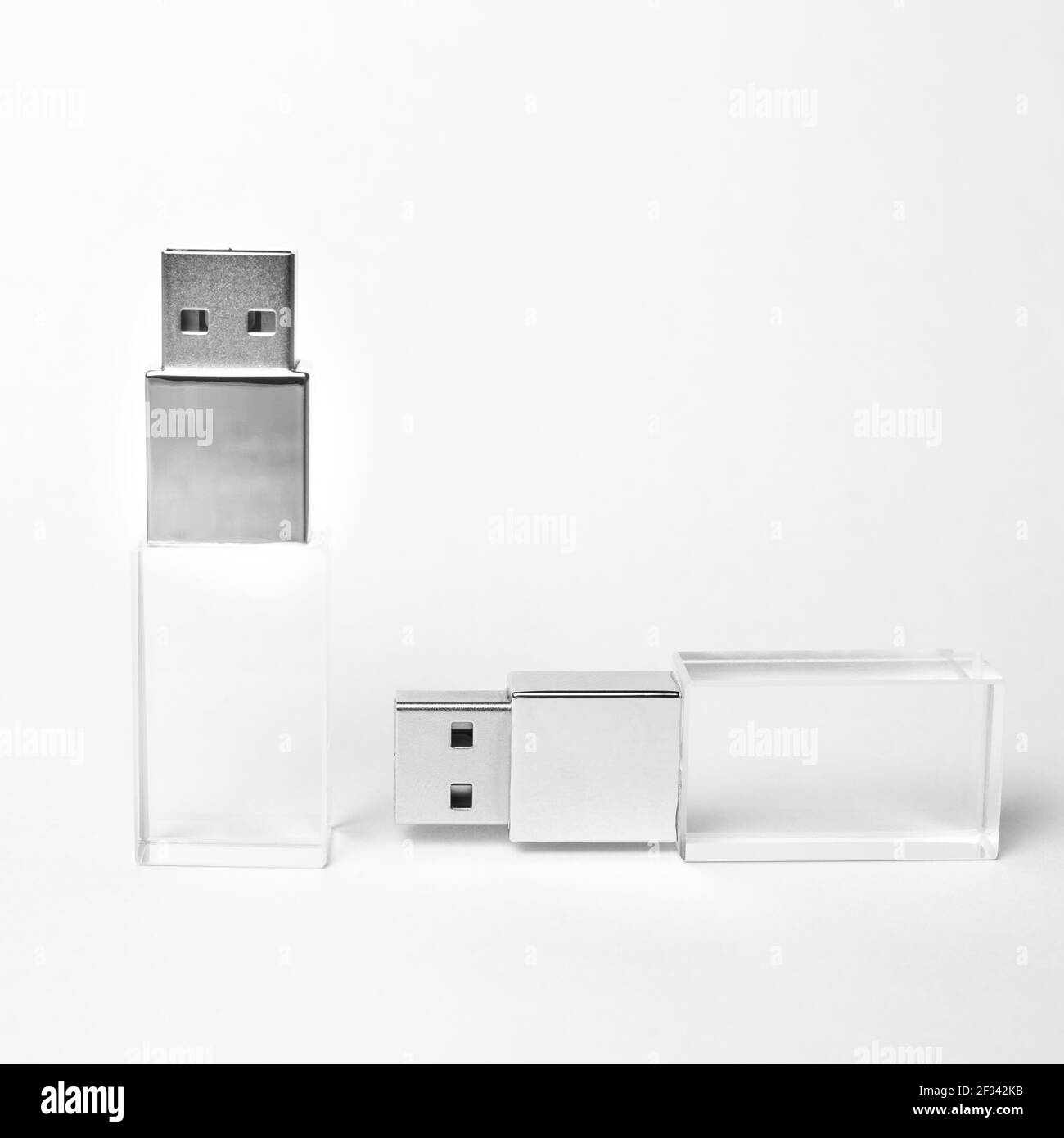 Two glass transparent USB drives with a metal insert on a grey ...