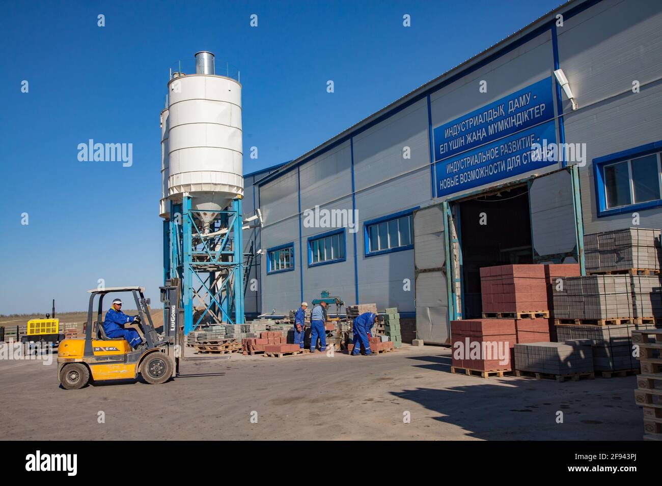 Paving tile production plant exterior. Electric cart and mixing silo ...