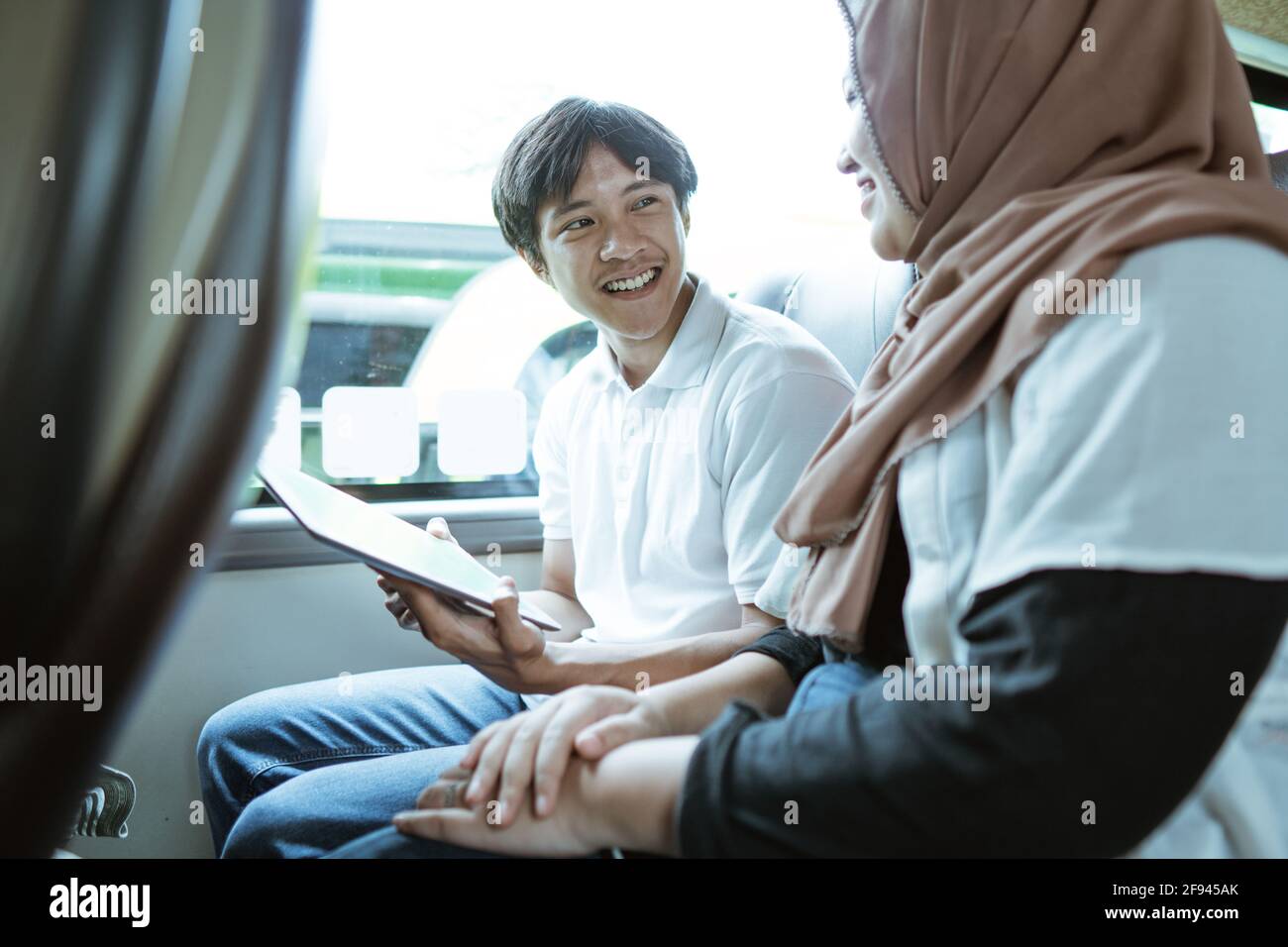 a young Muslim couple chatting and holding a pad together Stock Photo ...