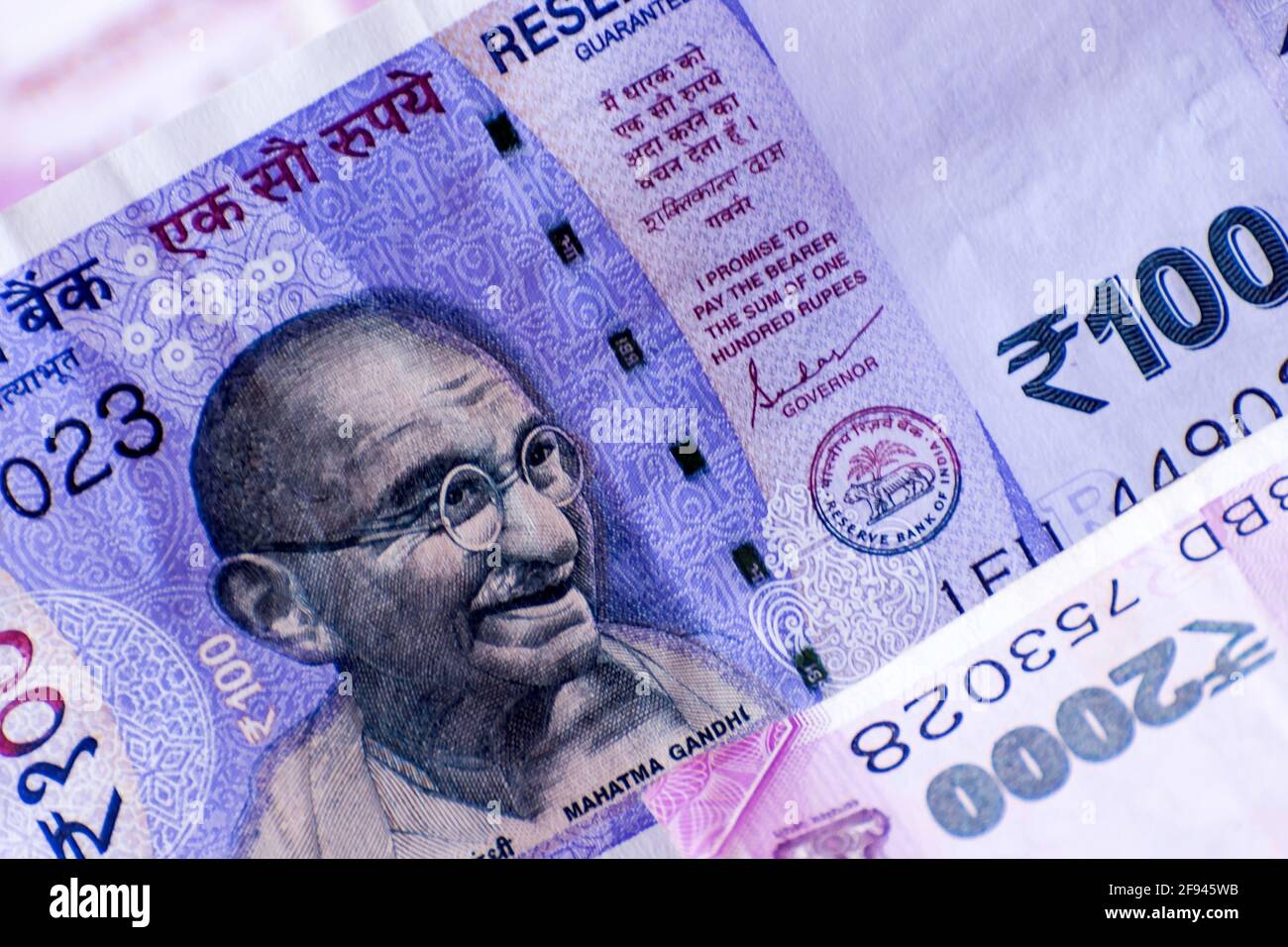 Close-up of one hundred Indian rupees against Indian paper currency ...