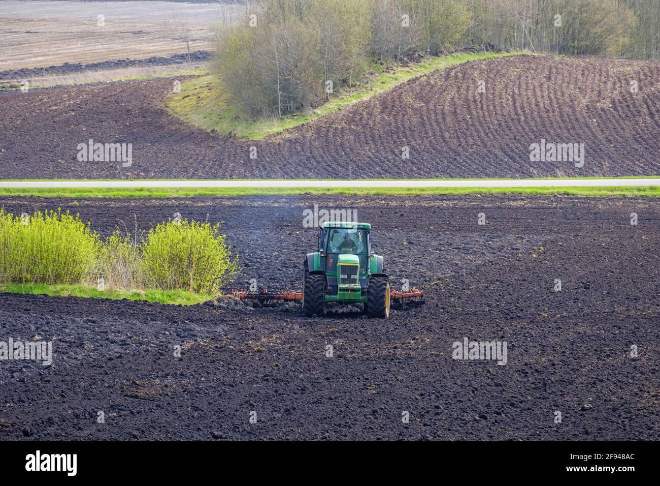 Tractor harrowing field in spring hi-res stock photography and images ...