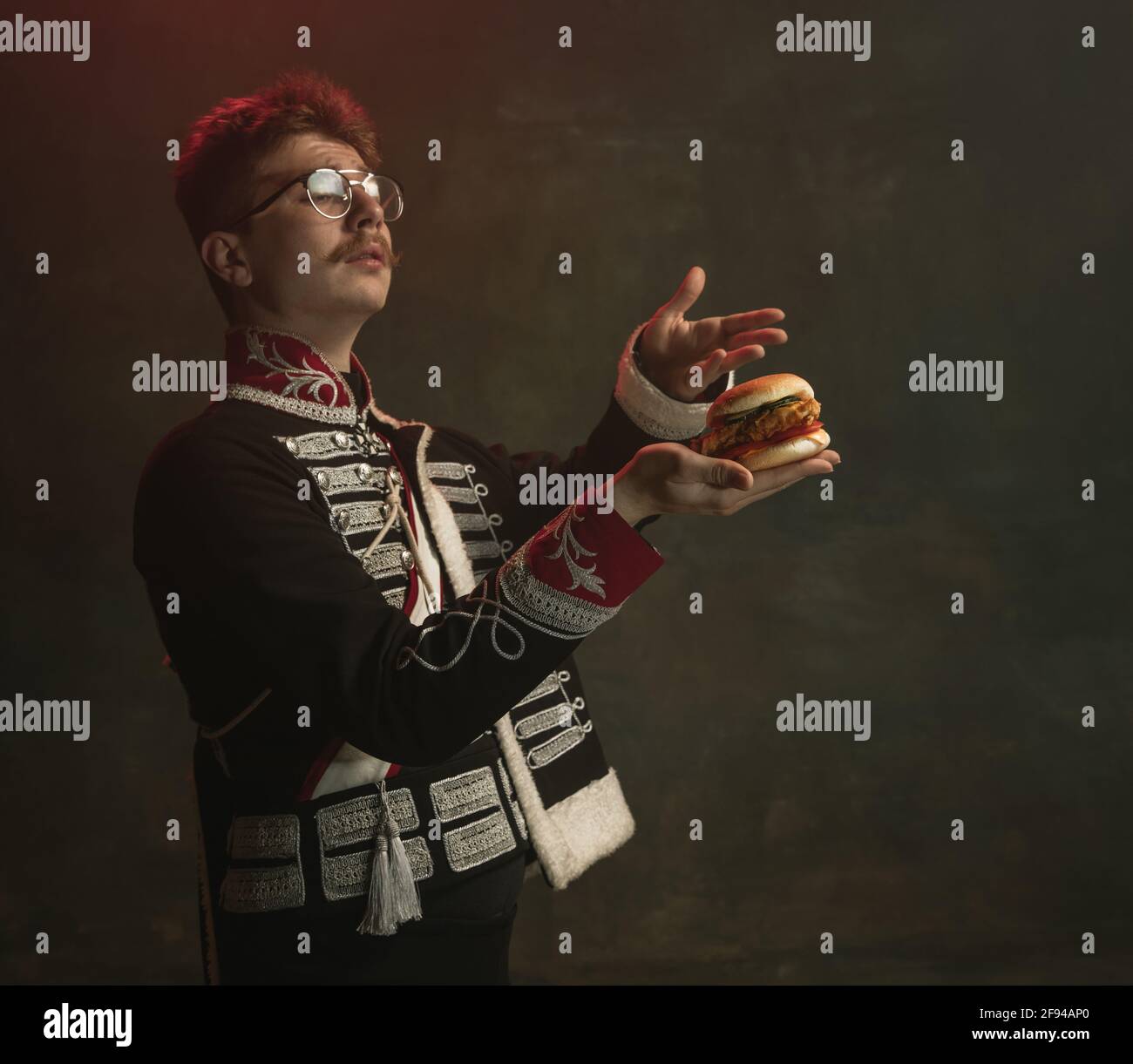 Young man in suit as royal person isolated on dark green background ...