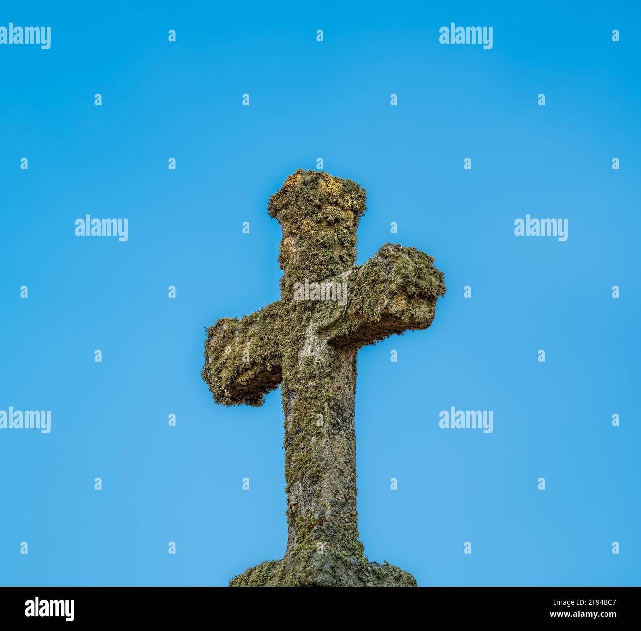 Antique old cross covered with moss against blue background Stock Photo ...