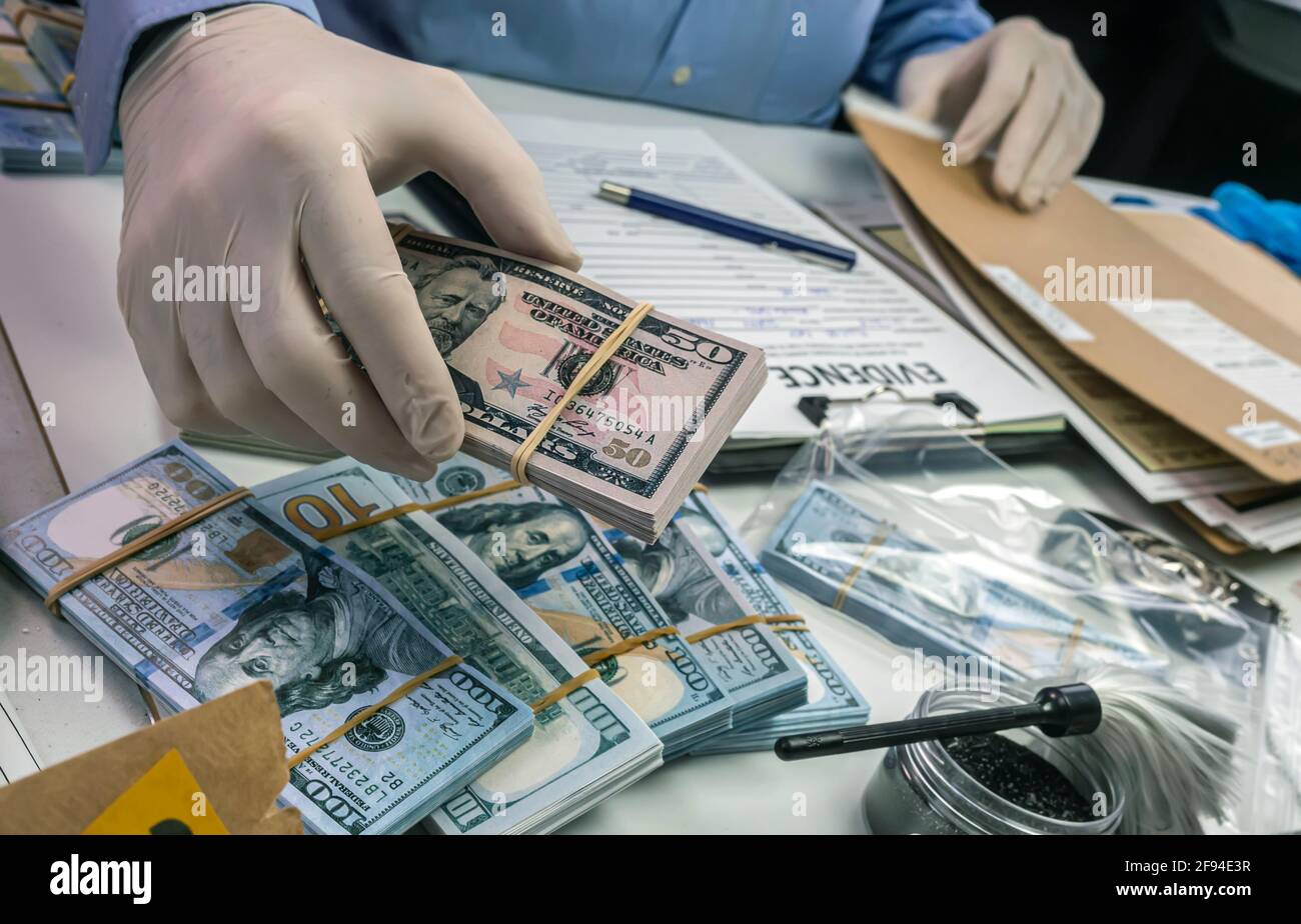 Specialised police officer notes dollar banknote reference of a robbery ...