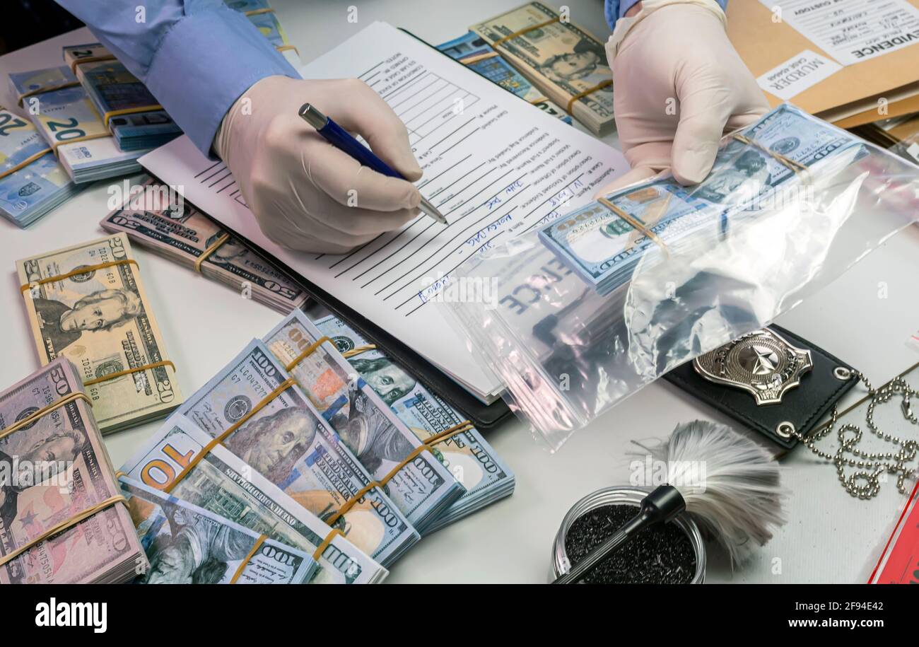 Specialised police officer notes dollar banknote reference of a robbery ...