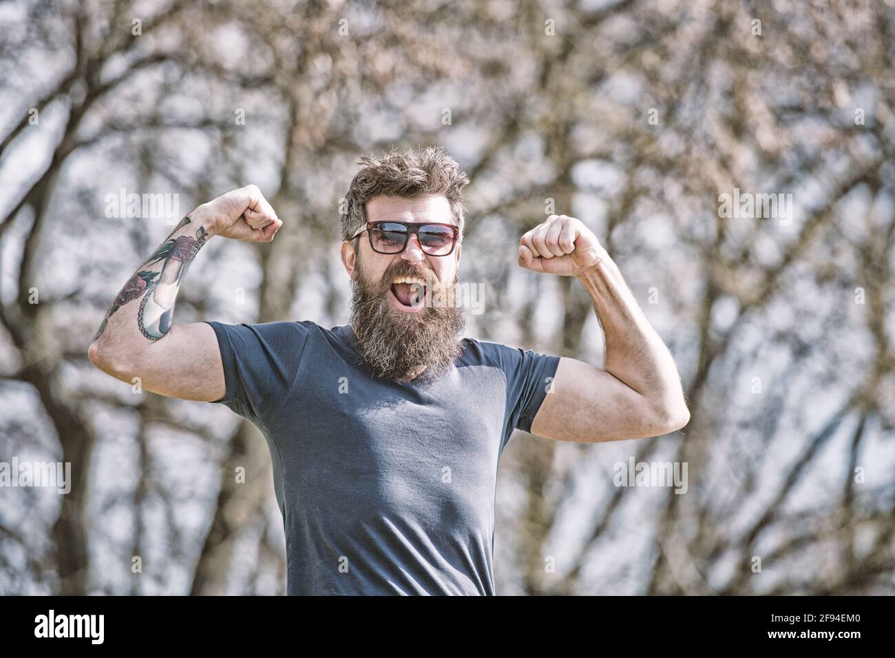 Bearded man shows muscles, biceps on sunny day. Masculinity concept ...